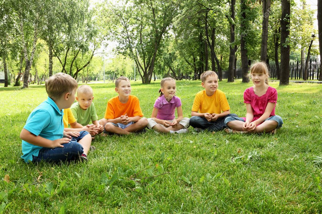 Group of children sitting together in the park Stock Photo by ...