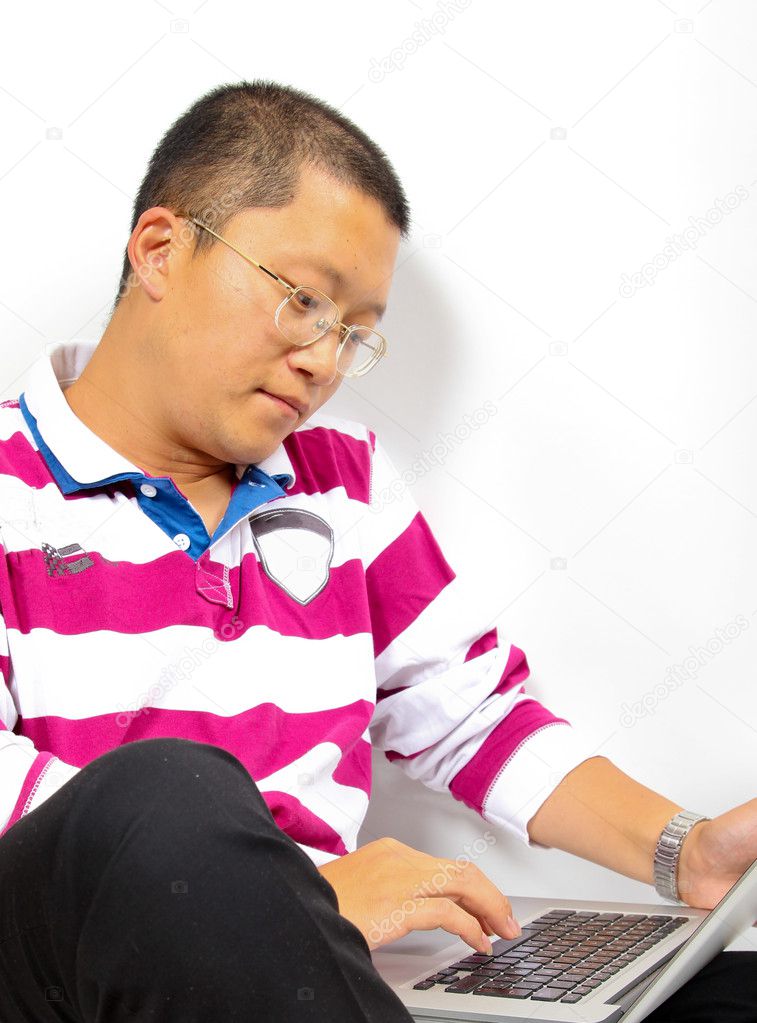 Young chinese man sitting with a laptop — Stock Photo © dotweb #6684104