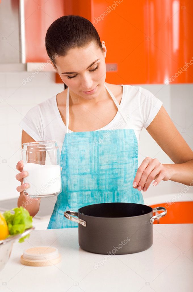 Beautiful young woman cooking in the kitchen — Stock Photo © dimmushka #5542768