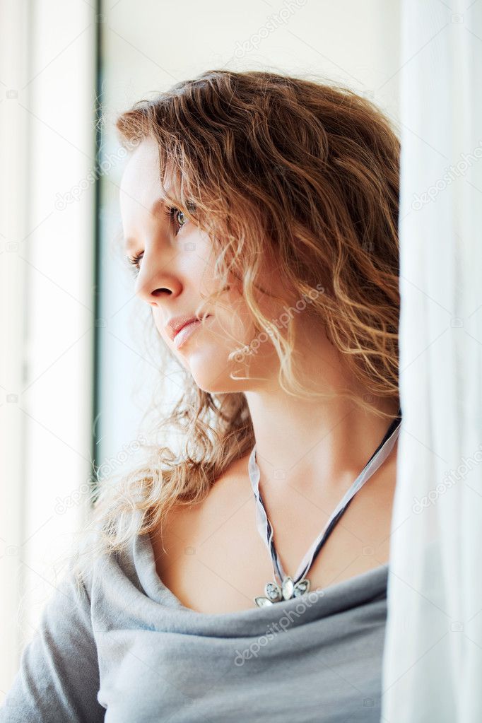 Sad woman looking through a window Stock Photo by ©wrangler 6350290