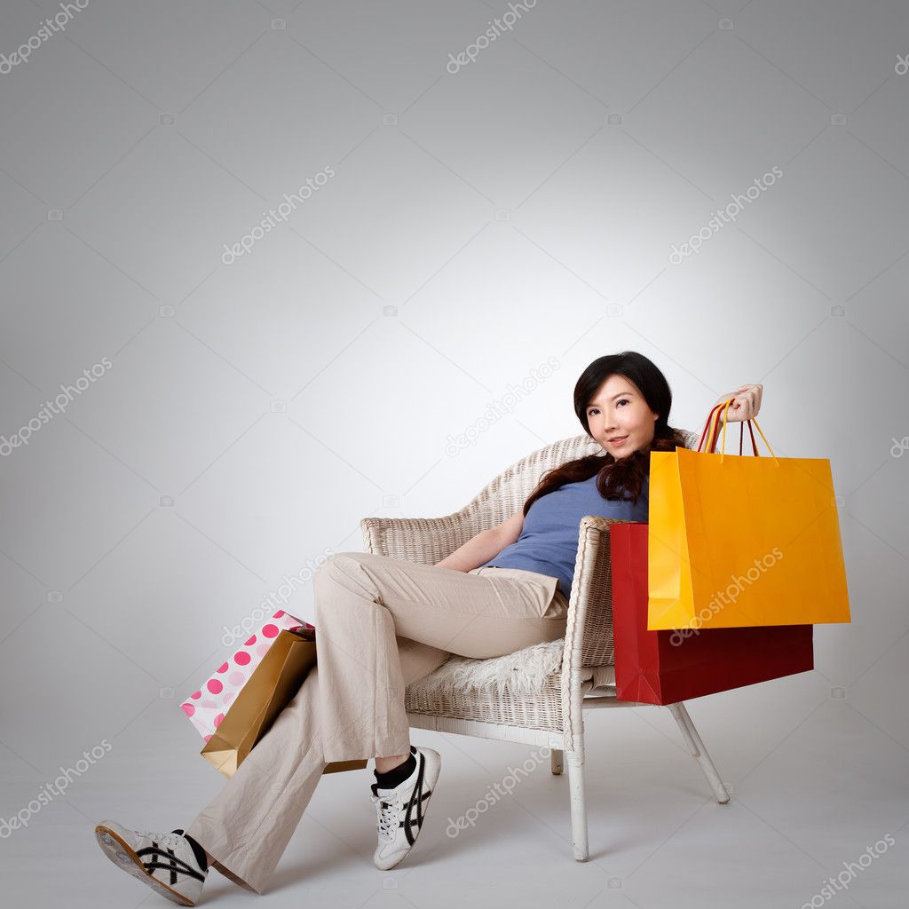 Shopping woman sitting on chair Stock Photo by ©elwynn 5631426