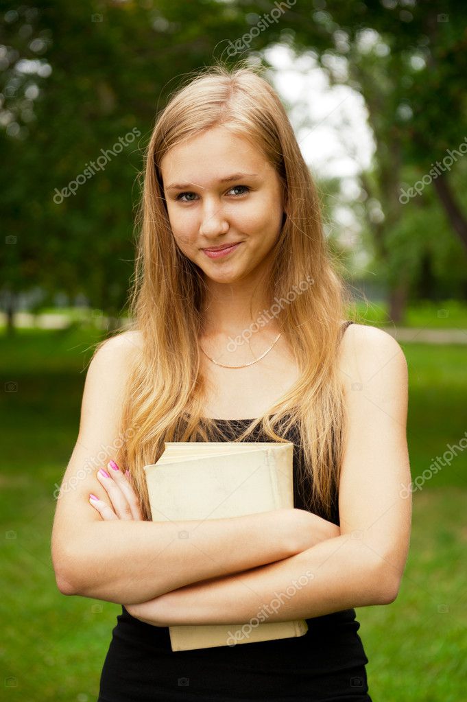 Beautiful female student outdoors with a book at campus park — Stock ...