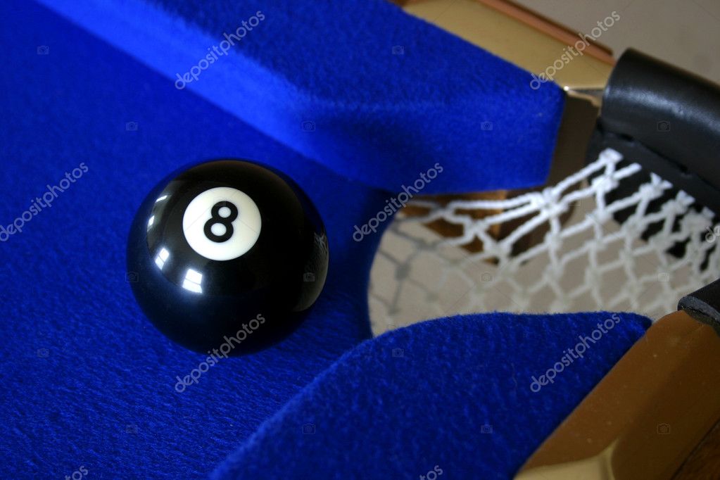 Number eight pool ball on blue pool table next to corner pocket Stock ...