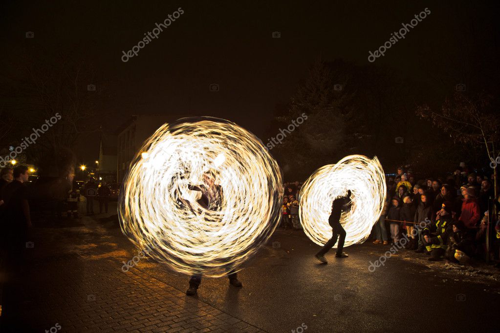 Young perform a fire spectacle at night for the audience of the Chri ...