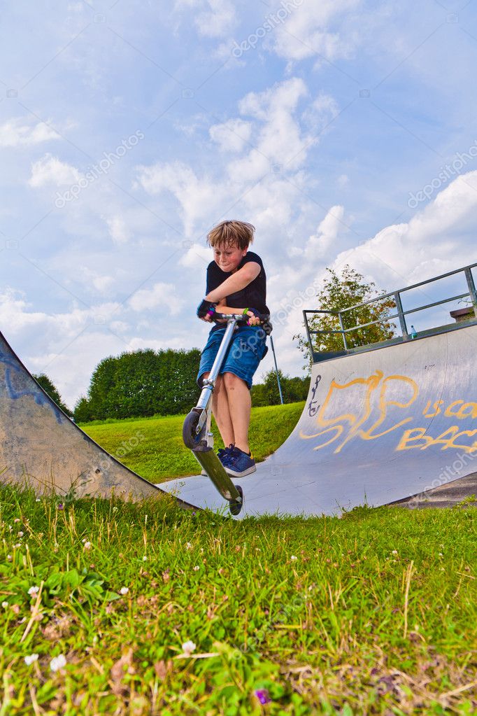 Boy is jumping with scooter in pipe — Stock Photo © Hackman #5674766