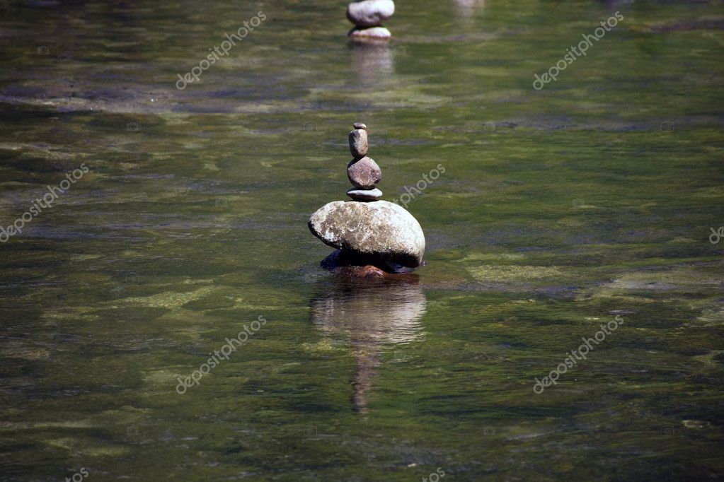 Stones in the merced river are looking as signs errected by huma ...