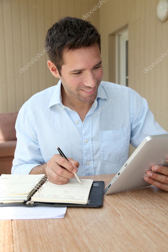 Man working at home with electronic tablet — Stock Photo © Goodluz #5695935