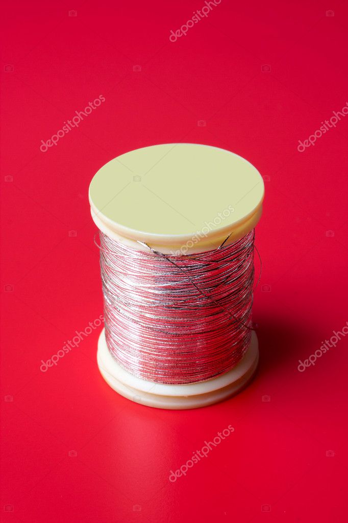 Bobbin of thread on a red background Stock Photo by ©broker 5882512