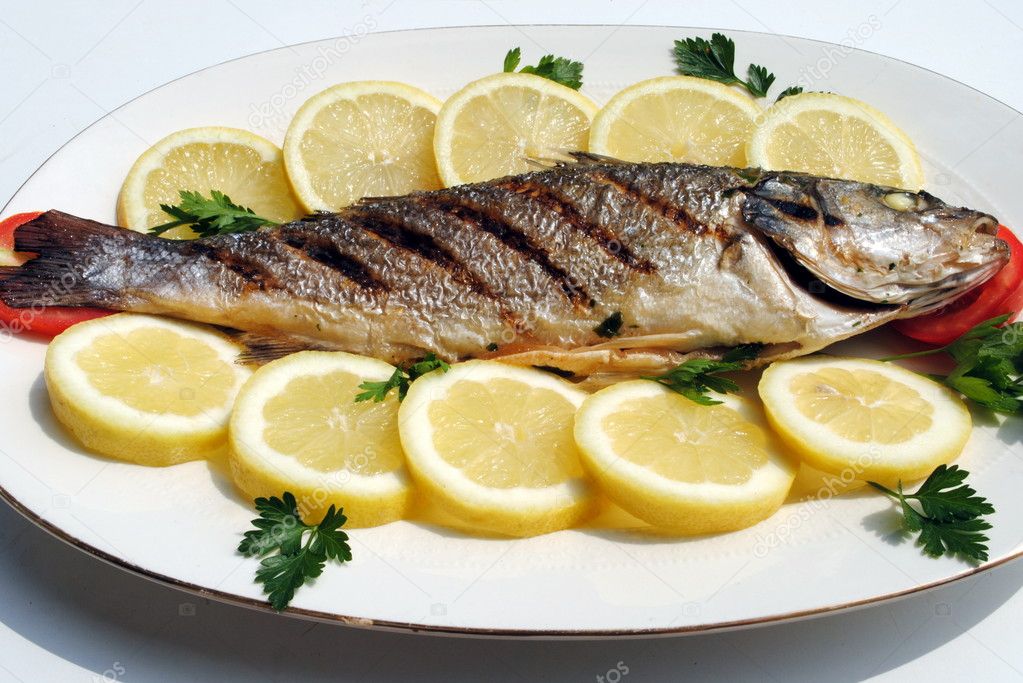 Griller du poisson cuit avec des tranches de citron — Photographie ...